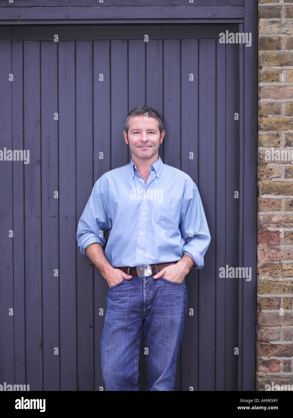 Man leaning against door Stock Photo - Alamy