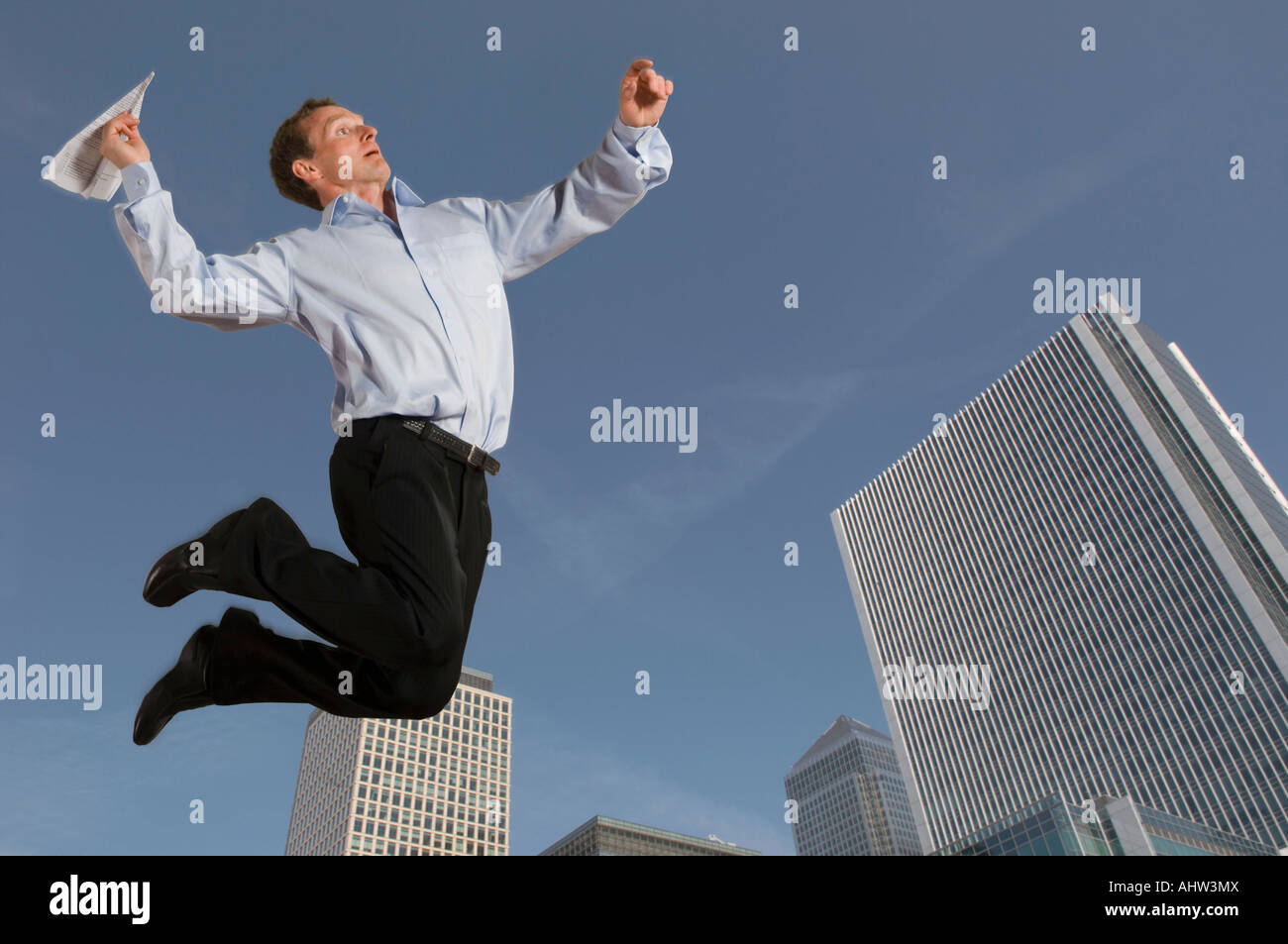 Businessman jumping with paper airplane Stock Photo - Alamy