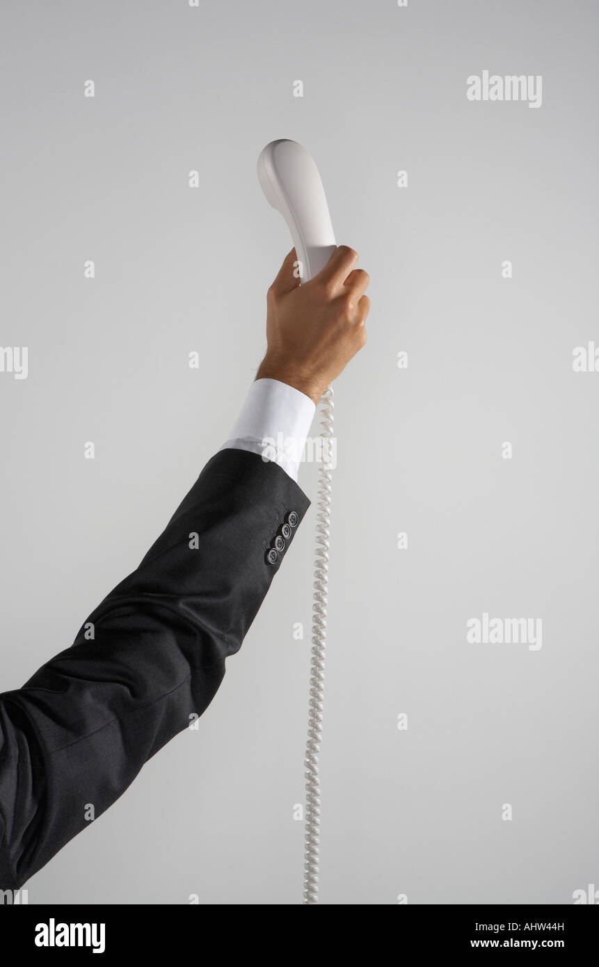 Man's arm holding up a telephone in the air Stock Photo - Alamy