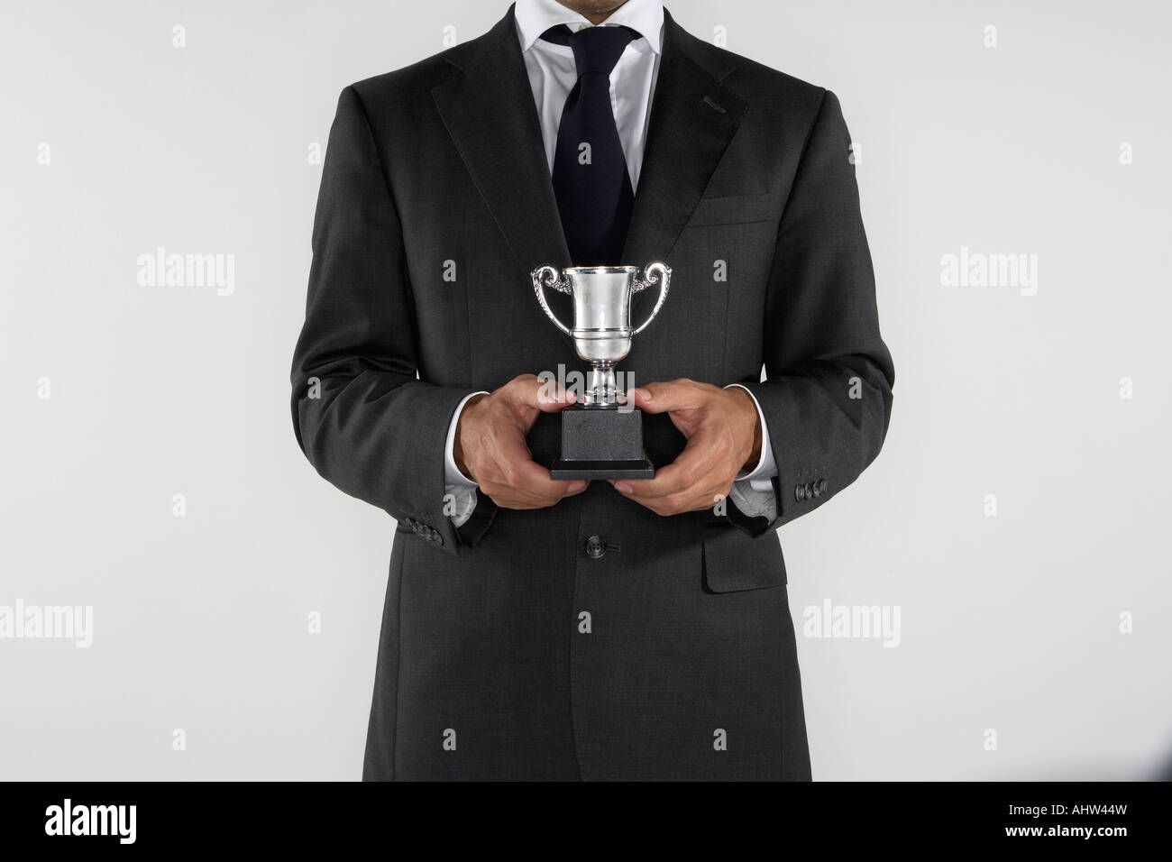 Man holding a small silver trophy Stock Photo - Alamy