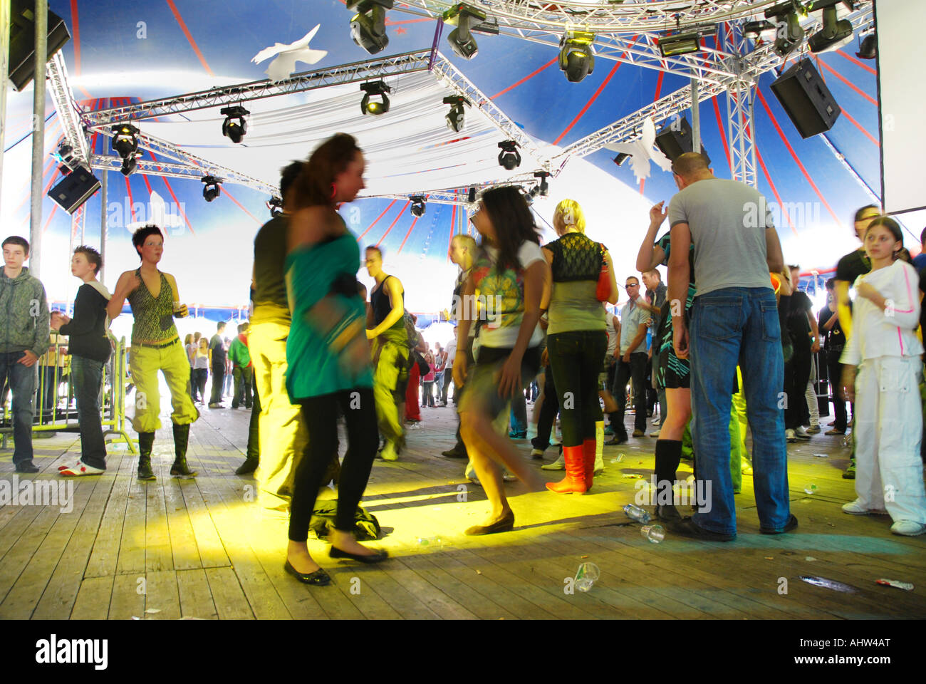 dancing crowd at dance festival in tent with stage lights and music ...