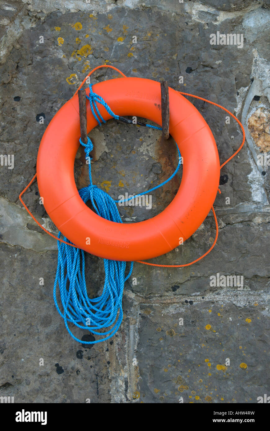 An Orange life saving ring on a harbour wall Stock Photo - Alamy