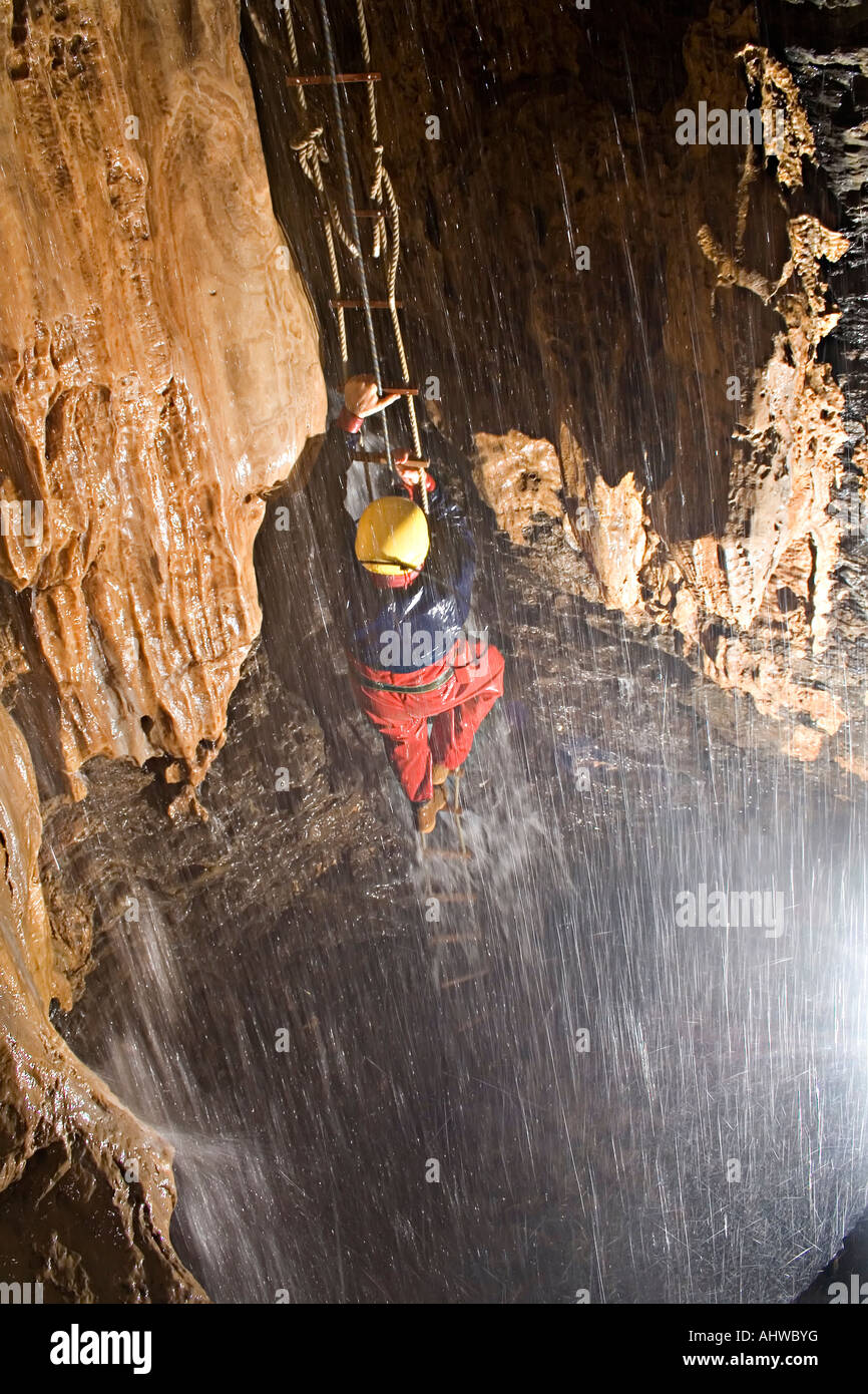 Caver on rope ladder for re creation of Forty descent Swildons Hole ...