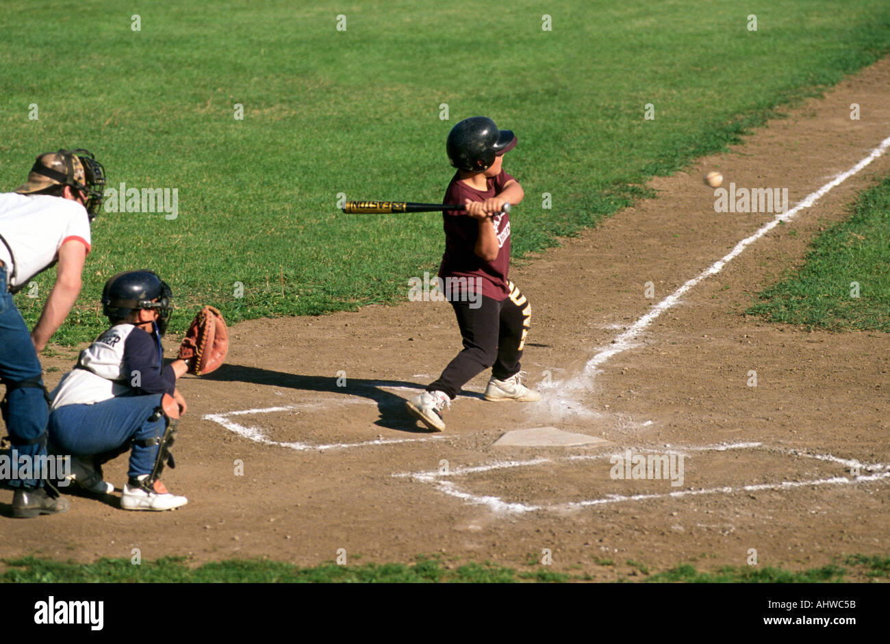 Little league action the batter hits the ball Stock Photo - Alamy