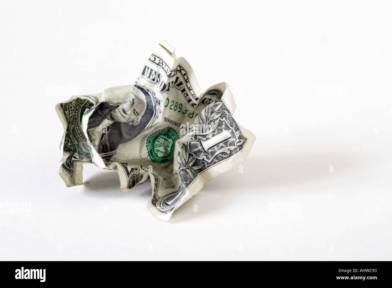 one dollar bill US currency wadded up lying on white table Stock Photo ...