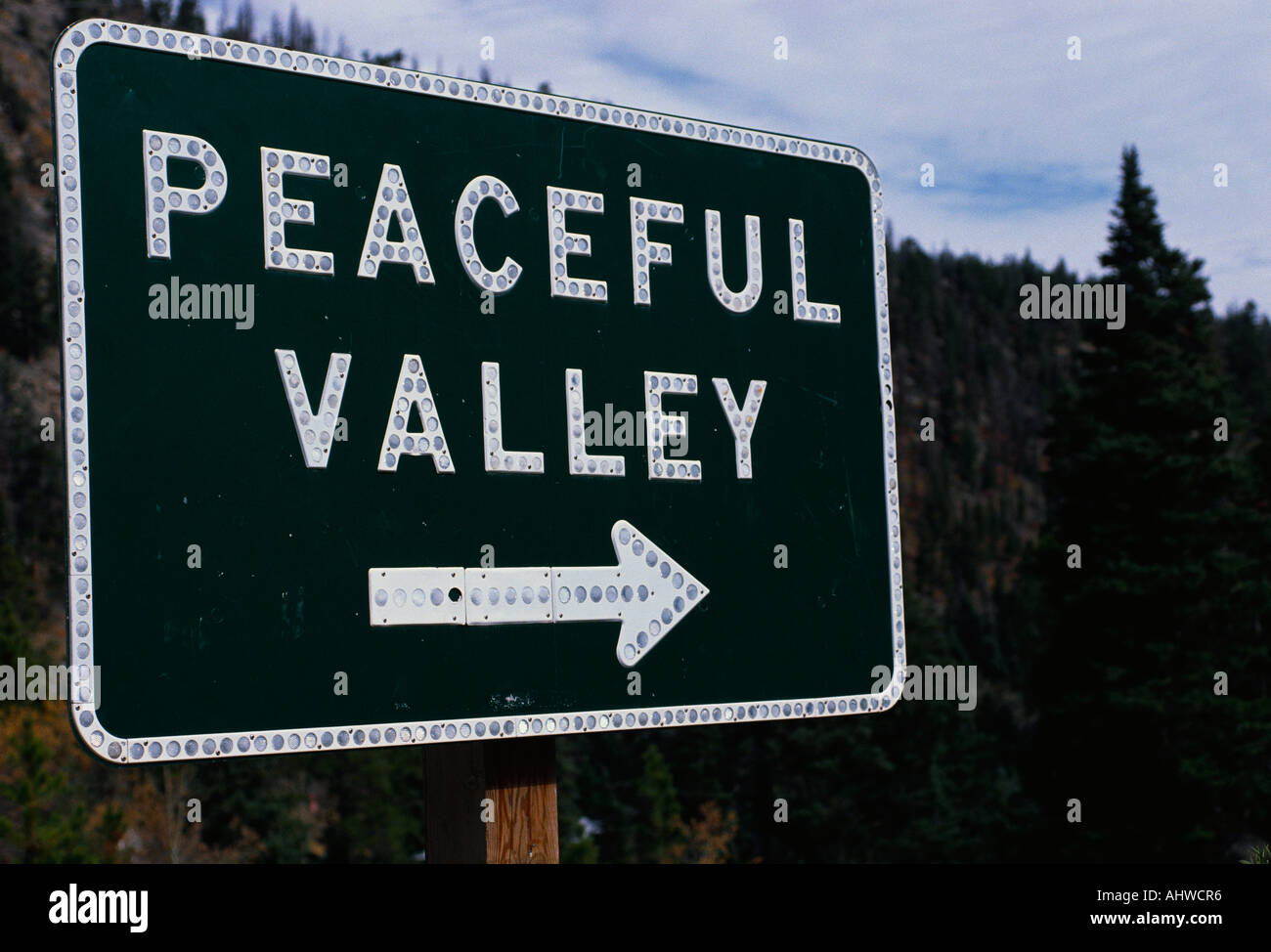 This is a road signs that says Peaceful Valley There is white arrow ...