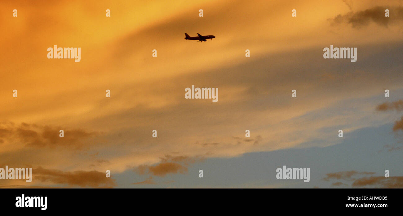 Airplane flying over port port Marina Botafoch in a cloudy sunset at ...