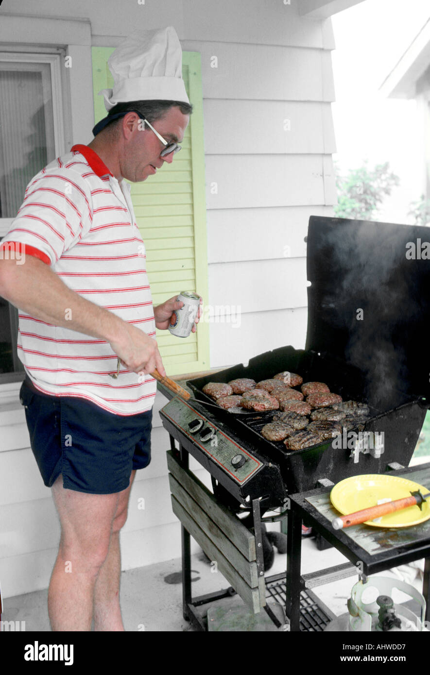Male drinks a can of beer as he cooks on an outdoor grill Stock Photo ...