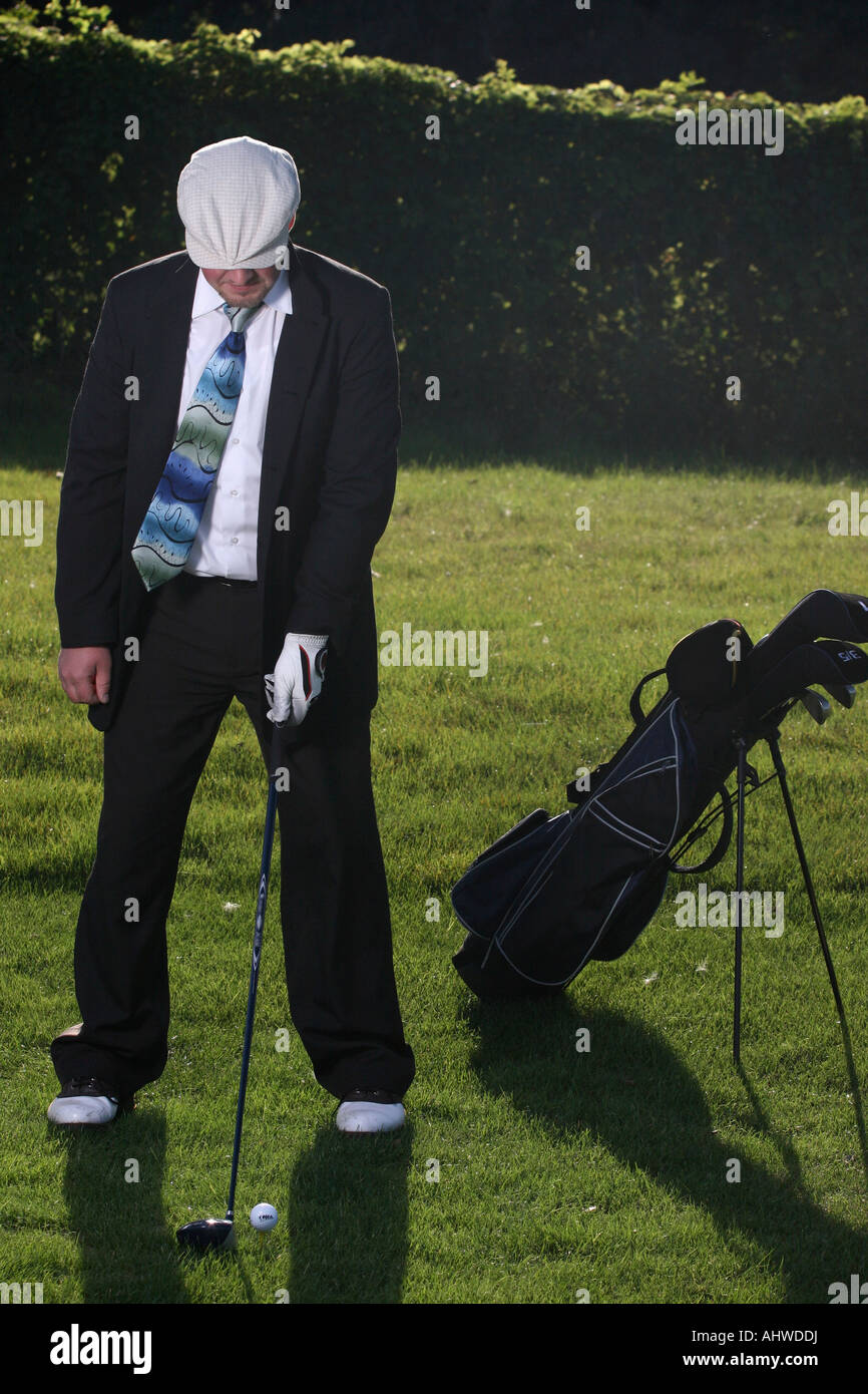 American golf courses young business man in full suit playing golf on ...