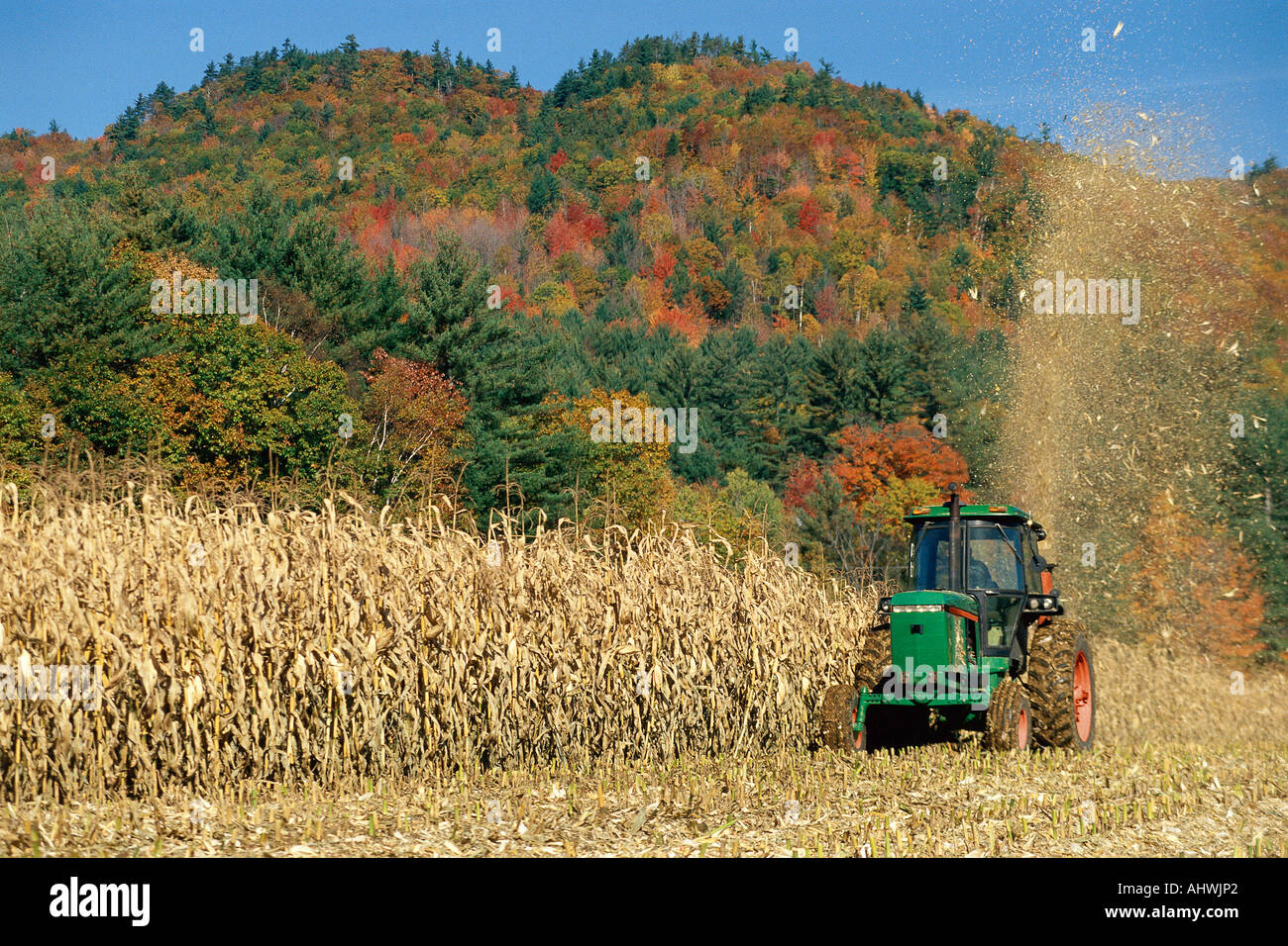 Tractor driving by field Stock Photo - Alamy