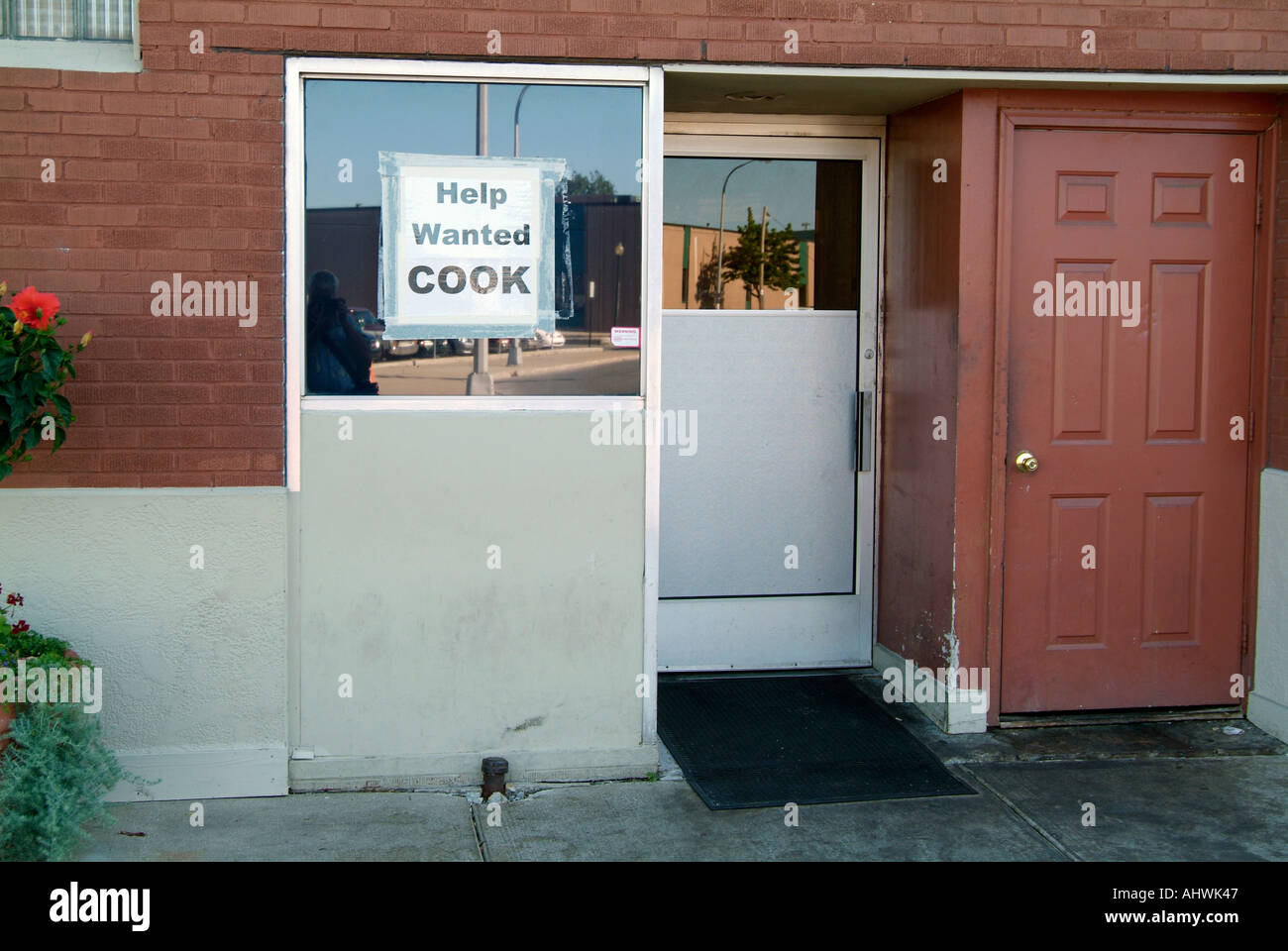 Help wanted sign post in the window of a restaurant Stock Photo - Alamy