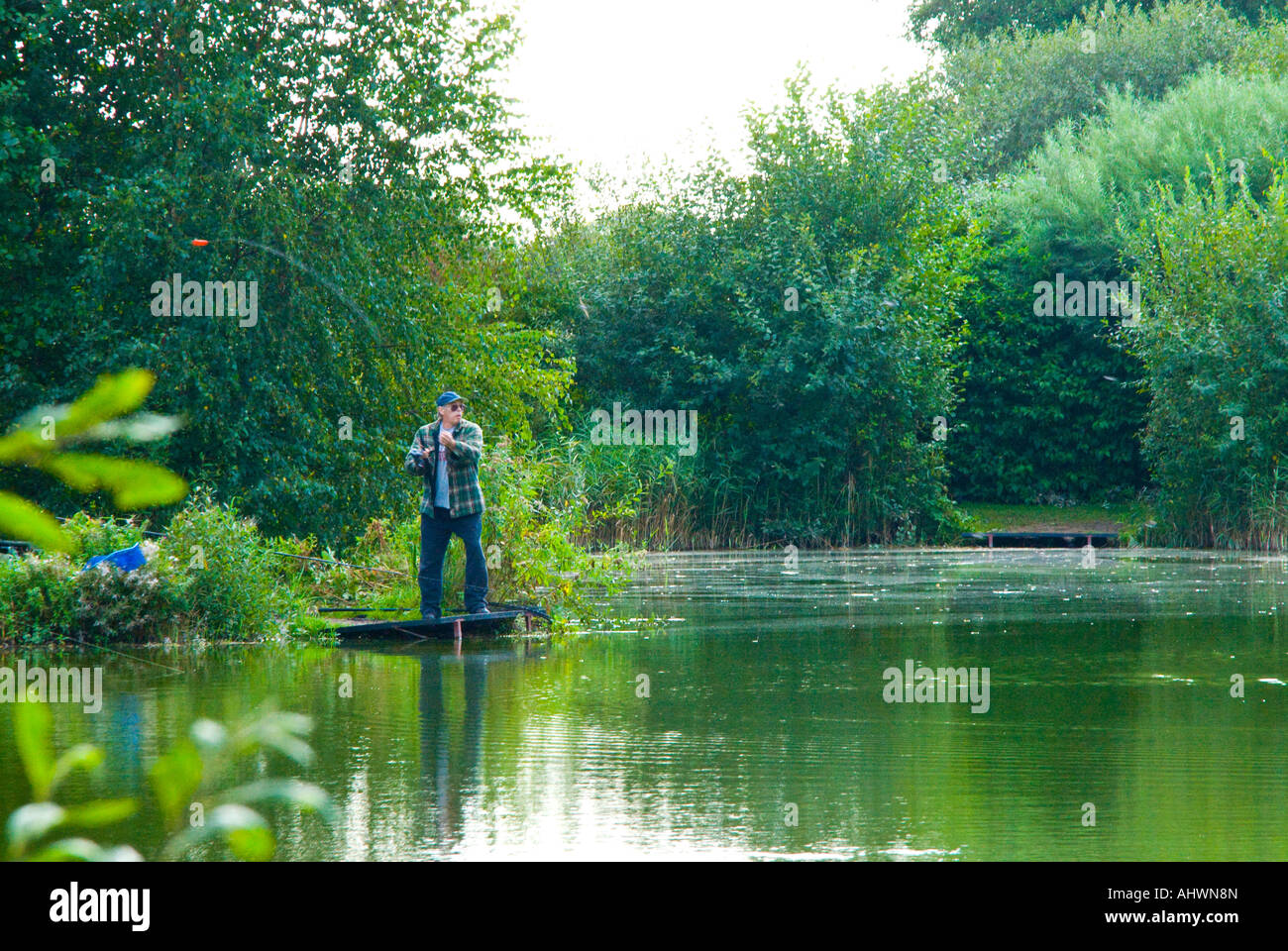 Man fishing on a lake Stock Photo - Alamy