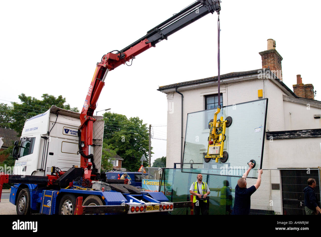 Fitting windows to the front of a shop in Diss Norfolk Stock Photo - Alamy