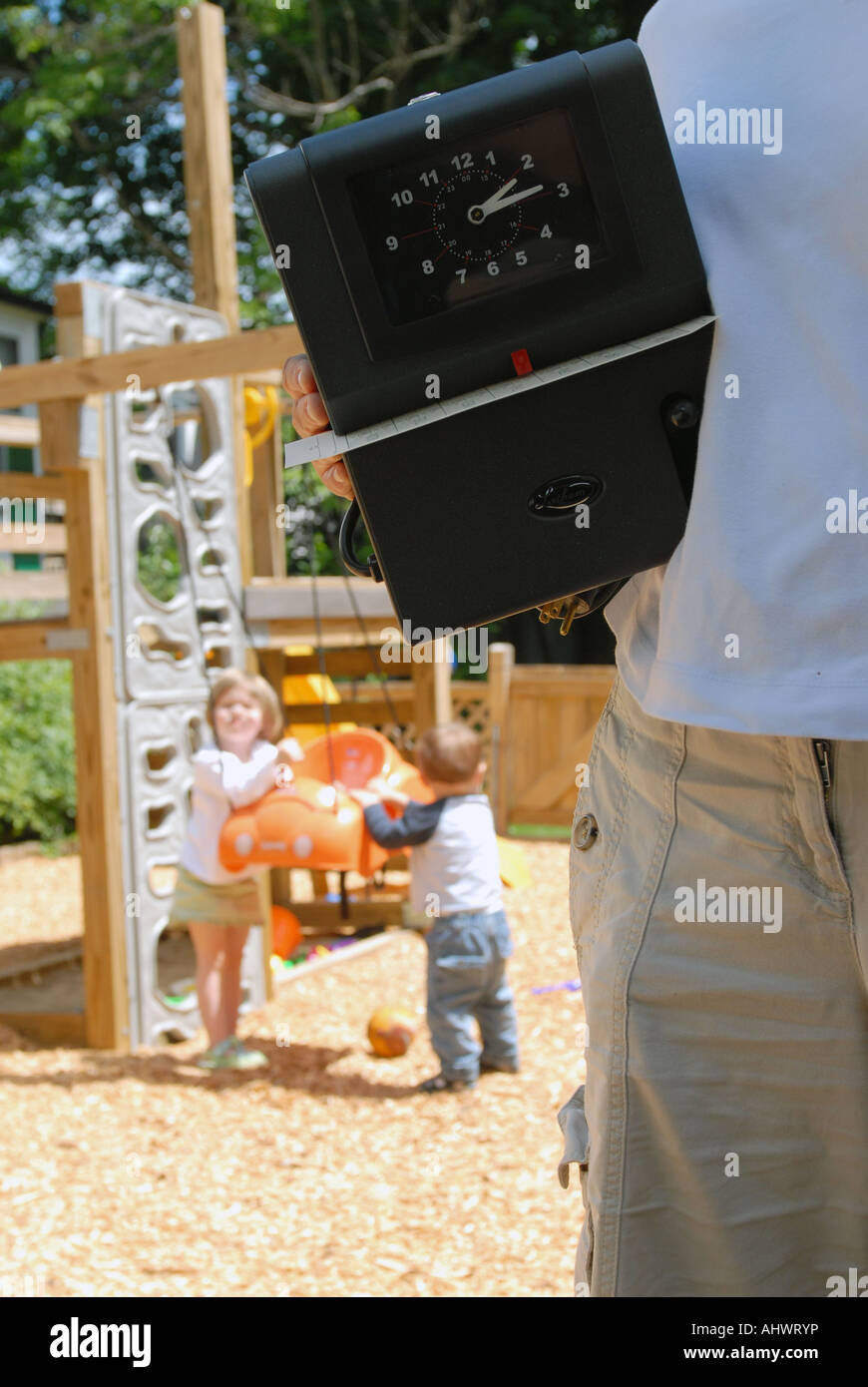 Electronic time clock held by mother in front of playground Stock Photo ...