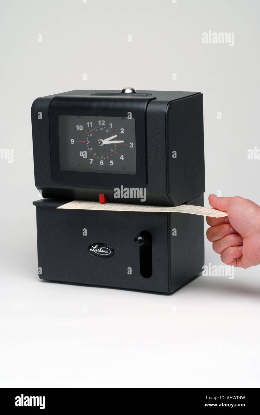 Electronic time clock on white seamless with hand inserting time card ...