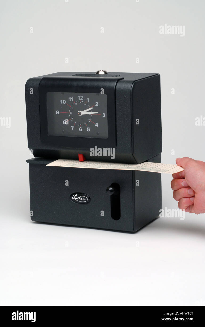 Electronic time clock on white seamless with hand inserting time card ...