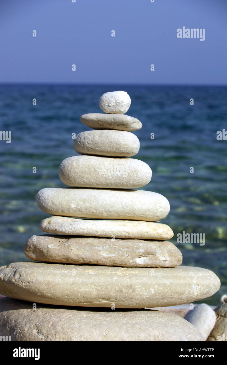 Pebble and rock stack by a blue sea Stock Photo - Alamy