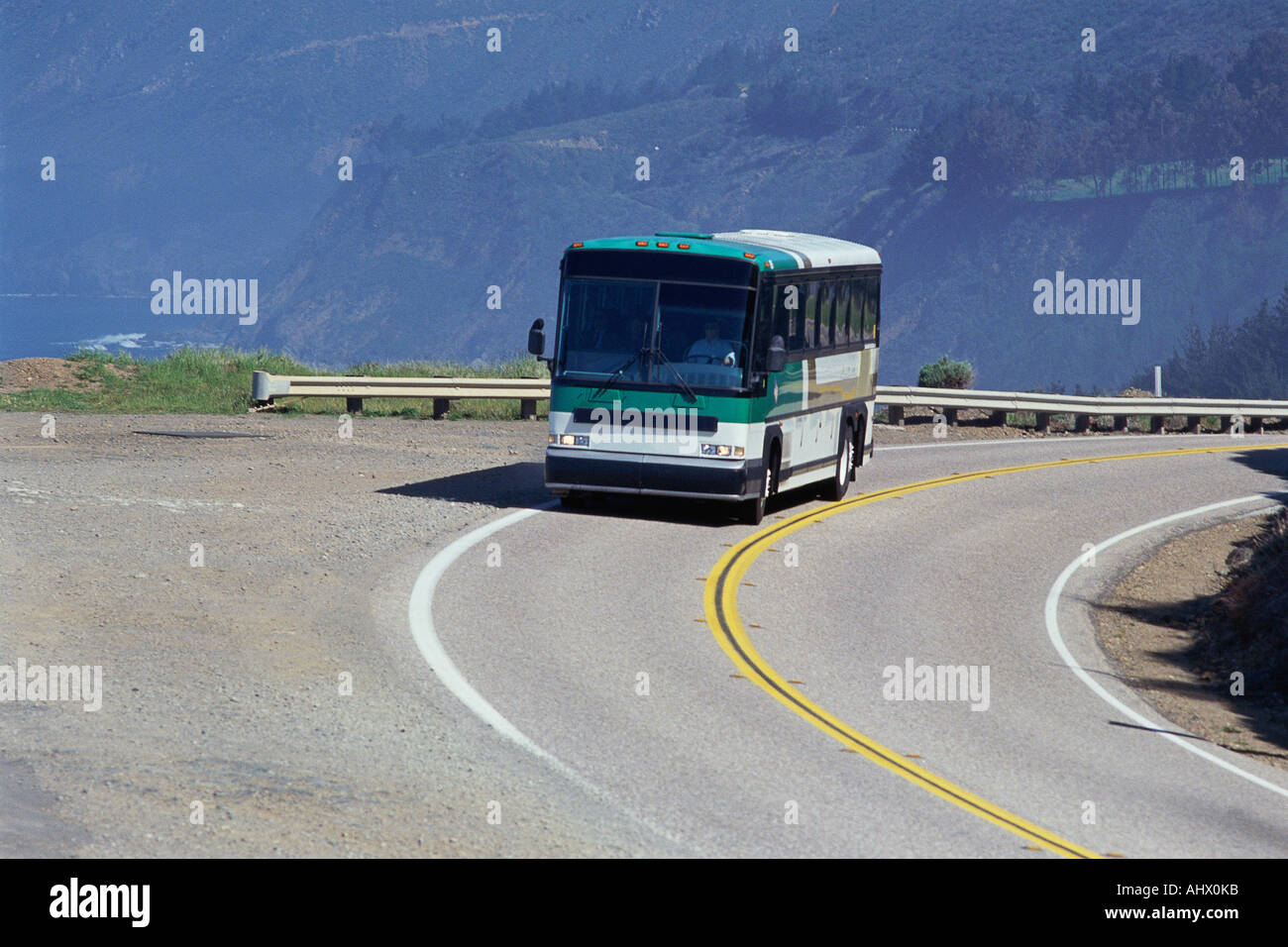 Bus rounding curve on road Stock Photo - Alamy