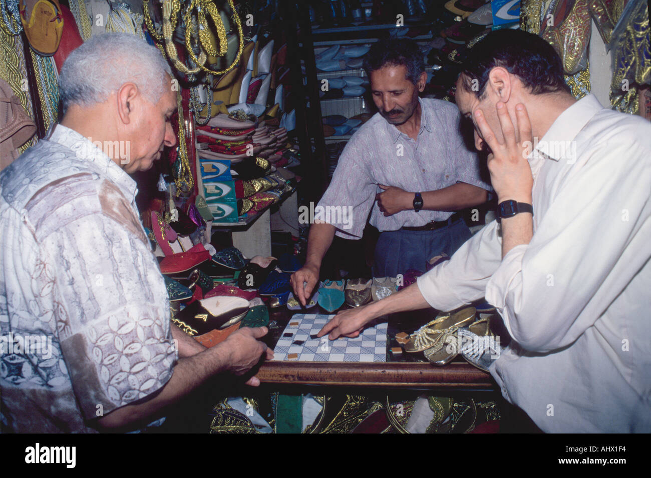 Three men relaxing with a board game in the medina, Meknes, Middle ...