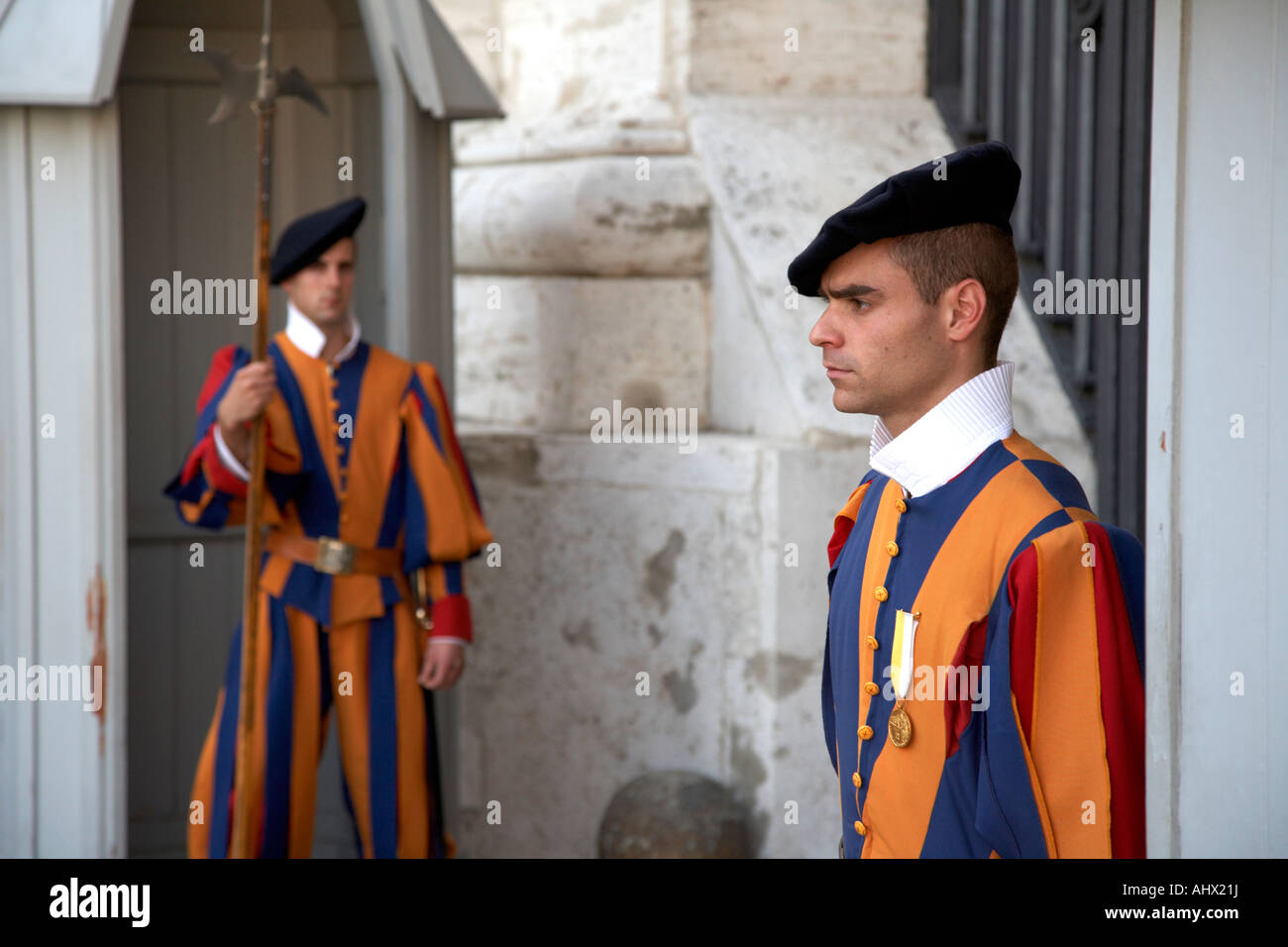 Two Papal Swiss Guards stand guard in traditional uniform with pike in ...