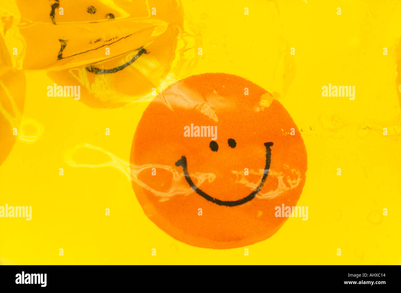 Happy faces floating in jello Stock Photo - Alamy