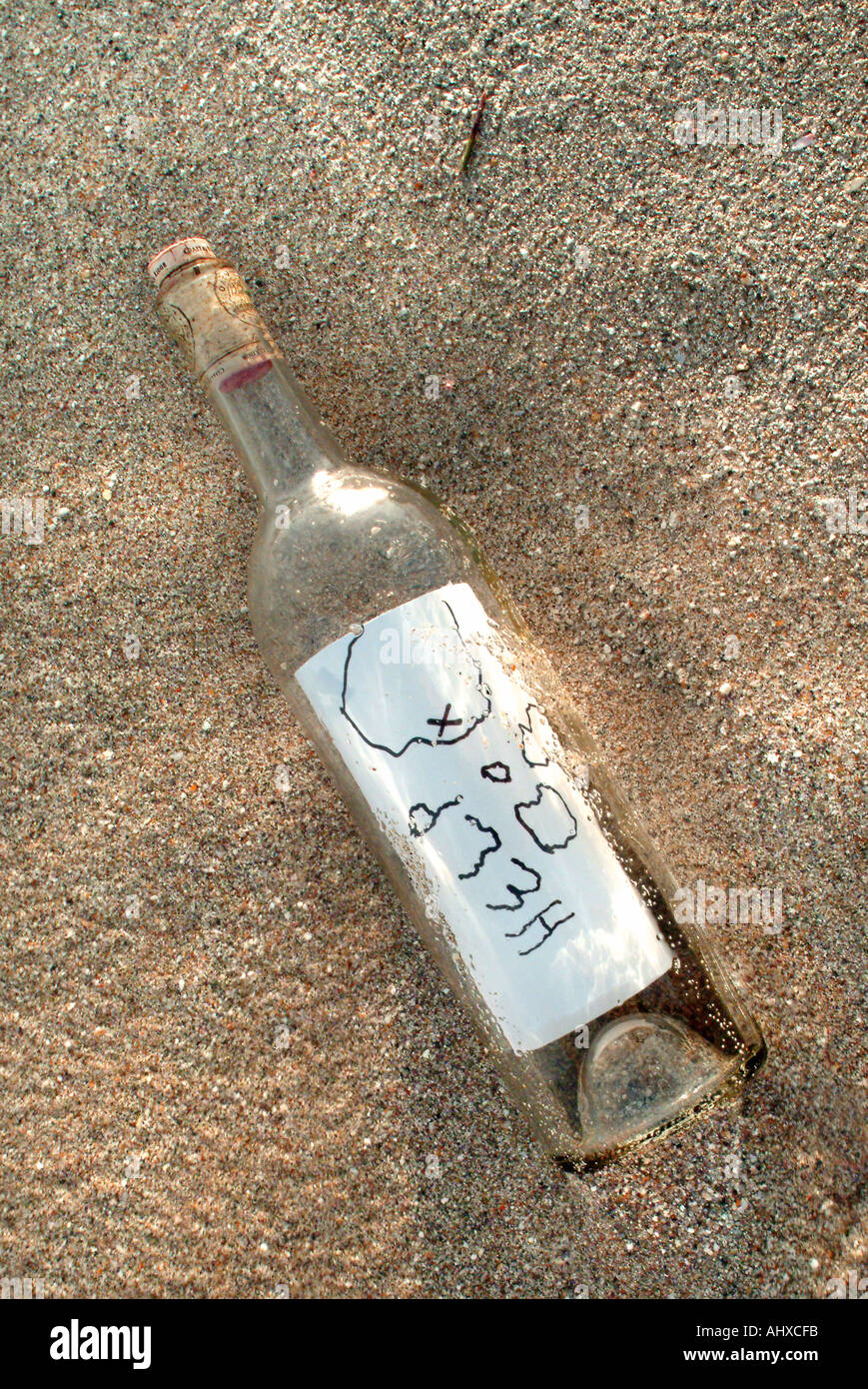 Message in a glass bottle washed up on sandy beach Stock Photo - Alamy