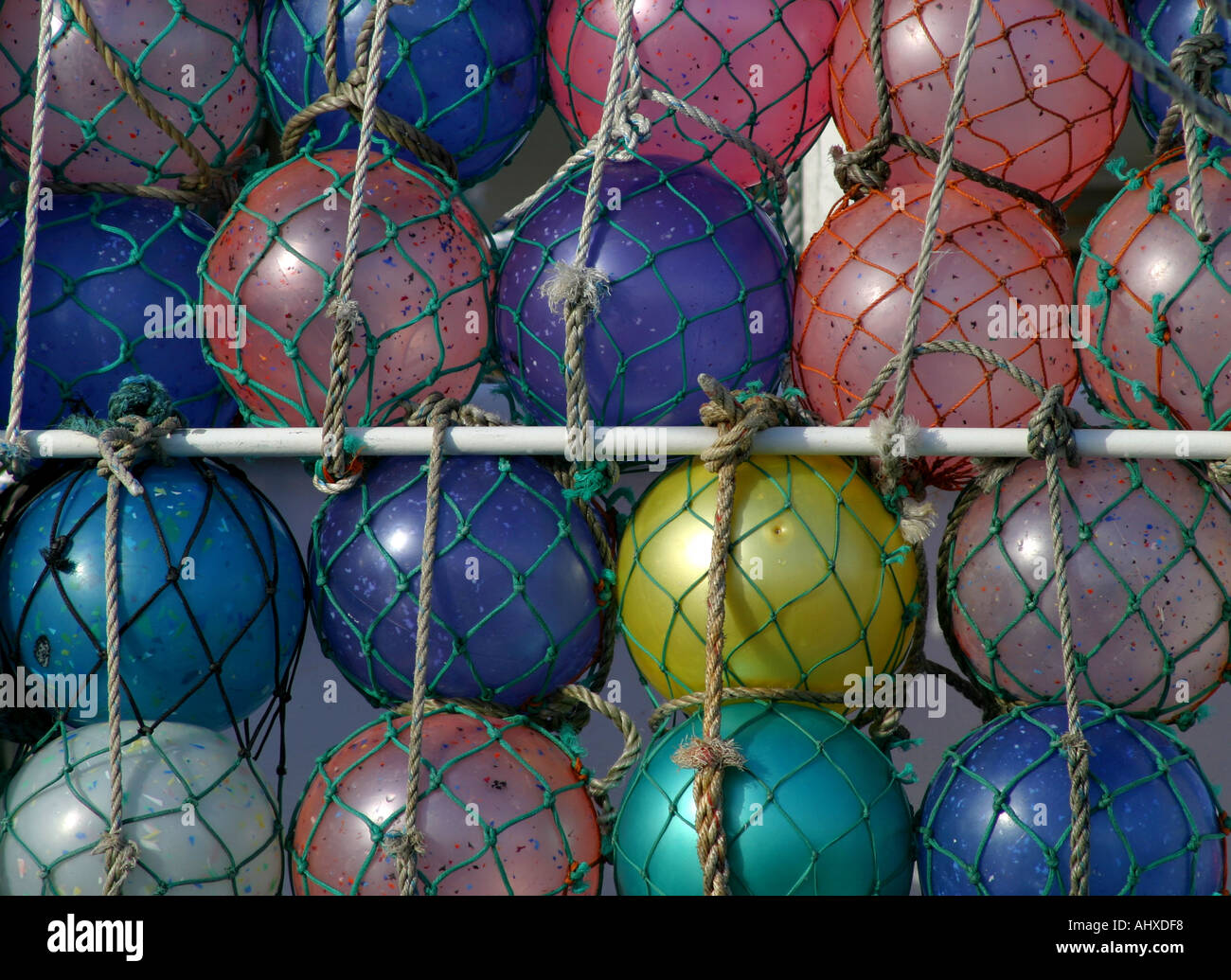 Rows of multi coloured buoys in netting Stock Photo - Alamy