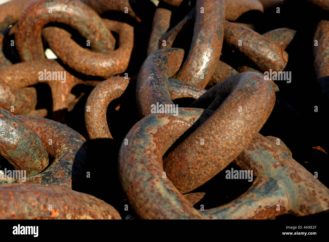 close up of the links in a length of large heavy duty industrial anchor chain rusty with ...