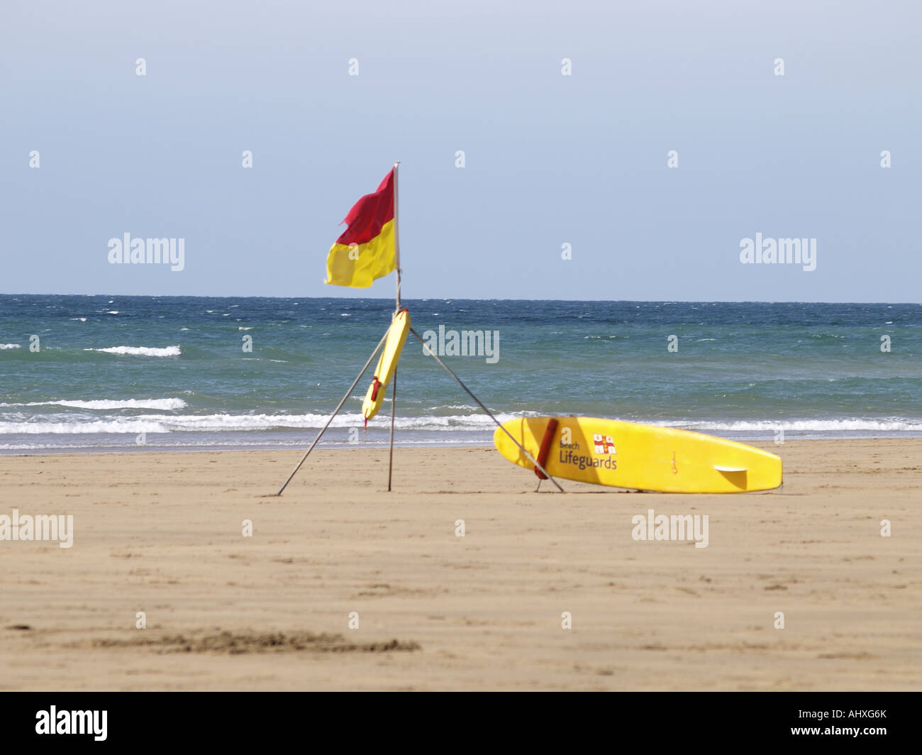 Lifeguards surfboard and marker flag on a sandy beach in Cornwall Stock ...