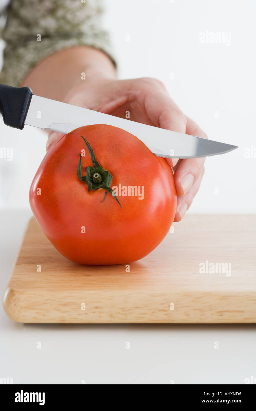 Hand slicing tomato Stock Photo - Alamy