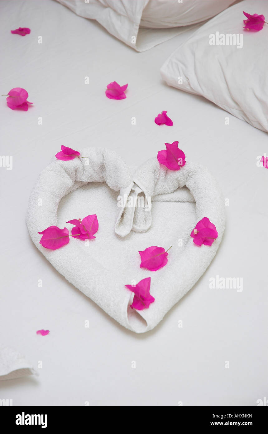 Heart shaped towel on bed in hotel room Stock Photo - Alamy