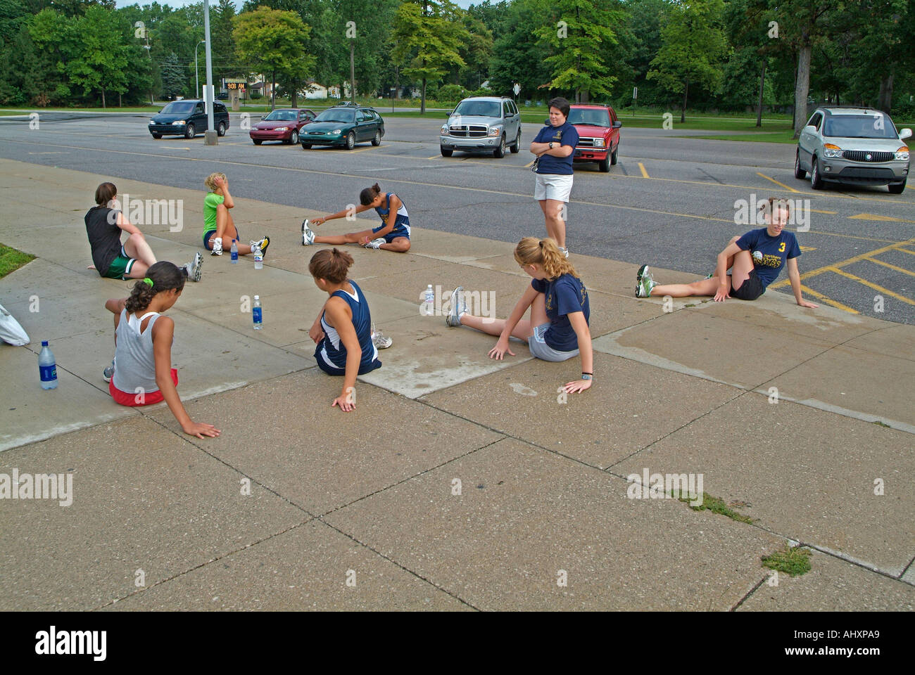 High school girls cross country running team stretches their muscles ...