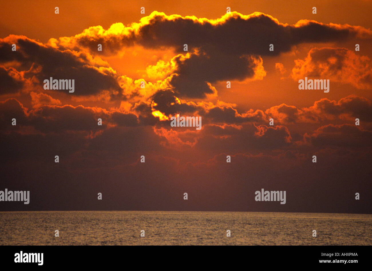 Maldives Kuredhu resort sun setting through cloud Stock Photo - Alamy
