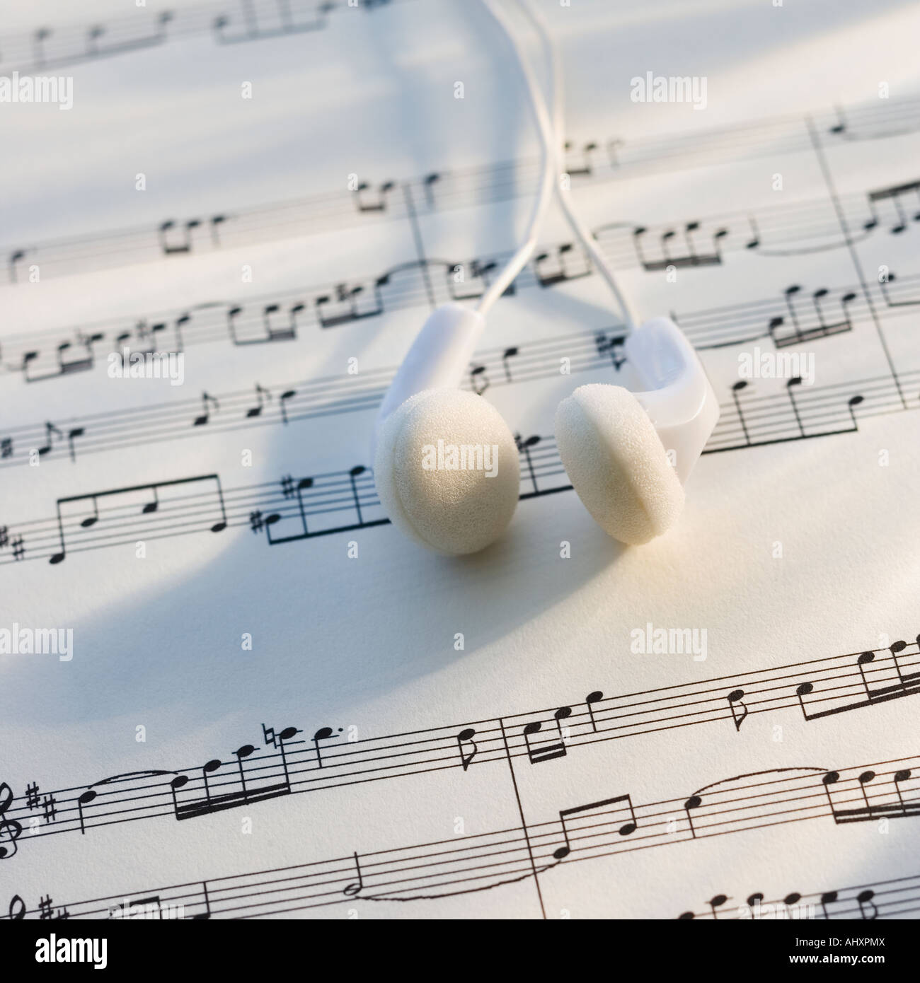 Close up of ear buds on sheet music Stock Photo - Alamy