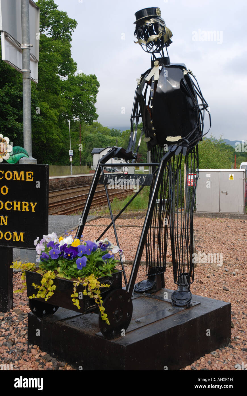 statue with flower pot of railroad worker with with luggage puller ...