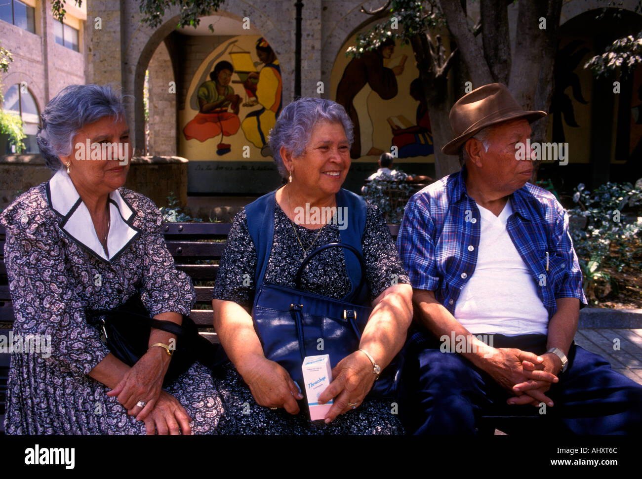 3 three Mexicans, Mexican women and man friends sitting on park bench ...