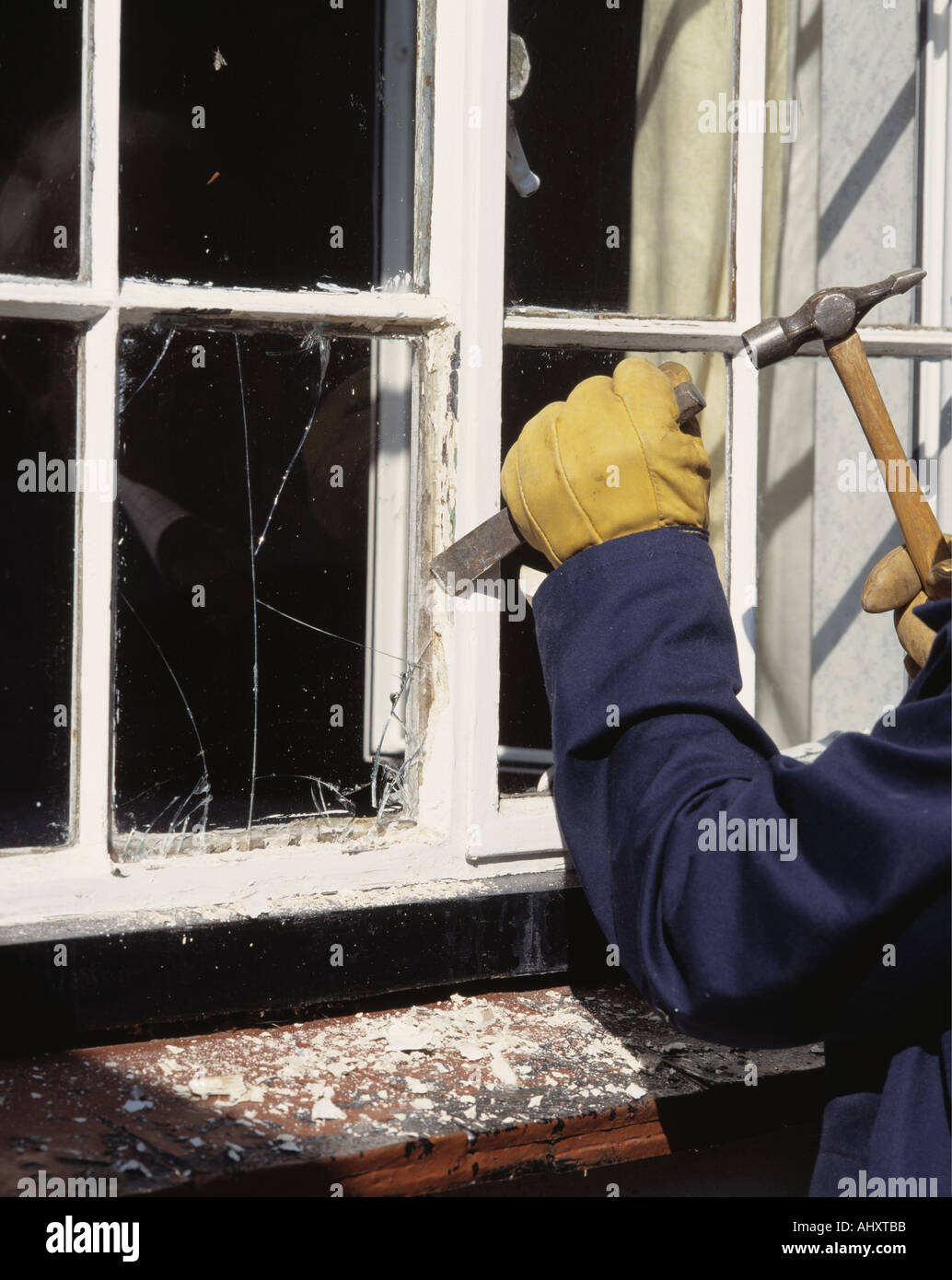 Close-up of man knocking out window pane before replacing with new ...