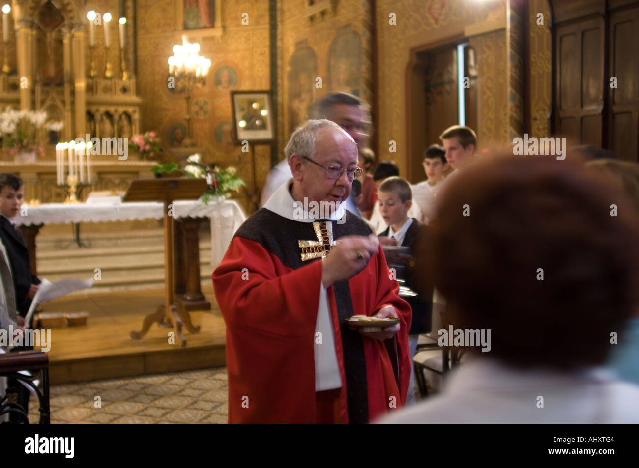 Catholic priest holding hostie about to give communion during mass in ...