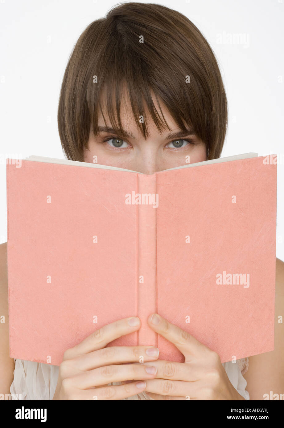 Woman holding open book over face Stock Photo - Alamy