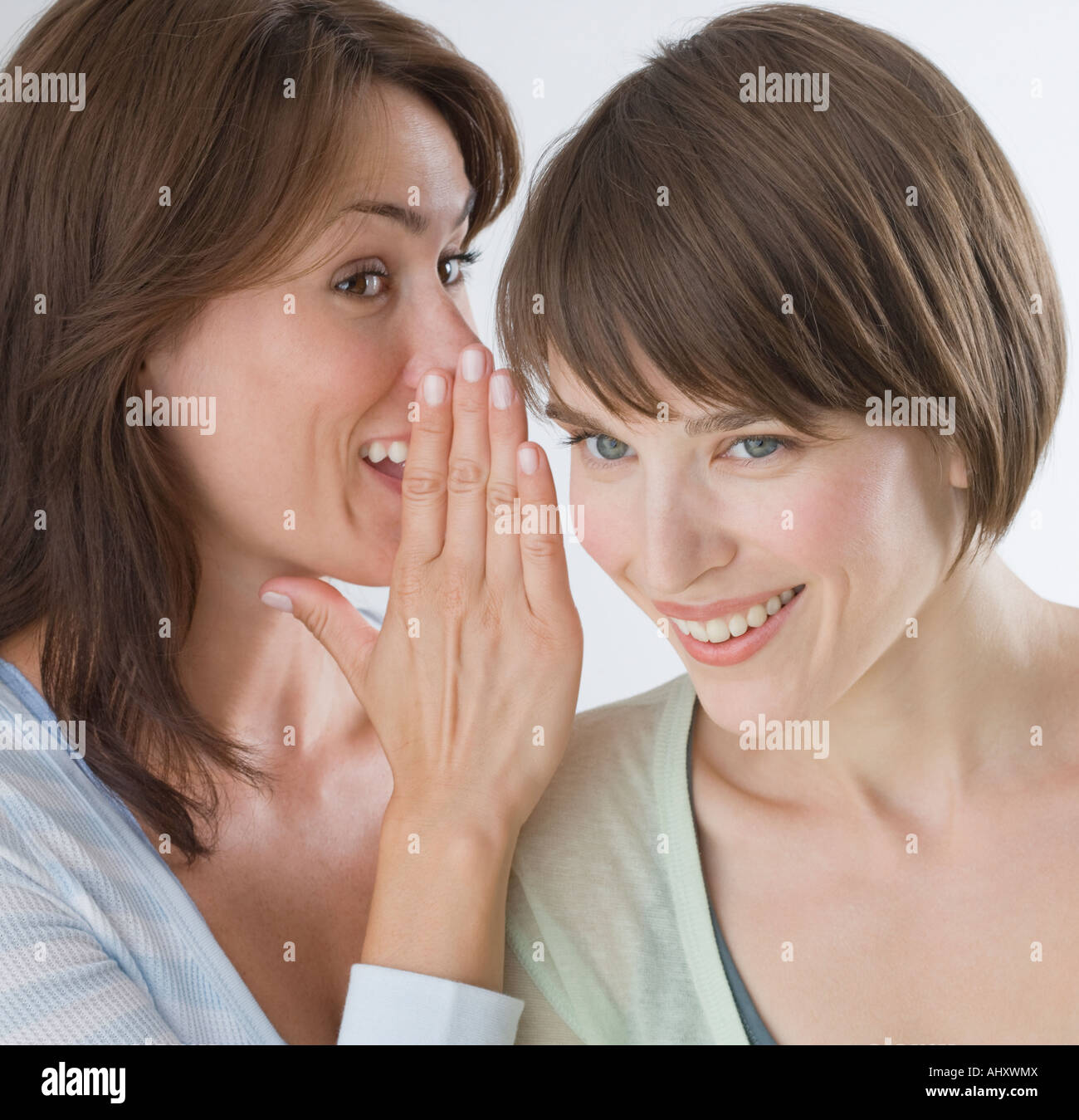 Woman telling secret to friend Stock Photo - Alamy