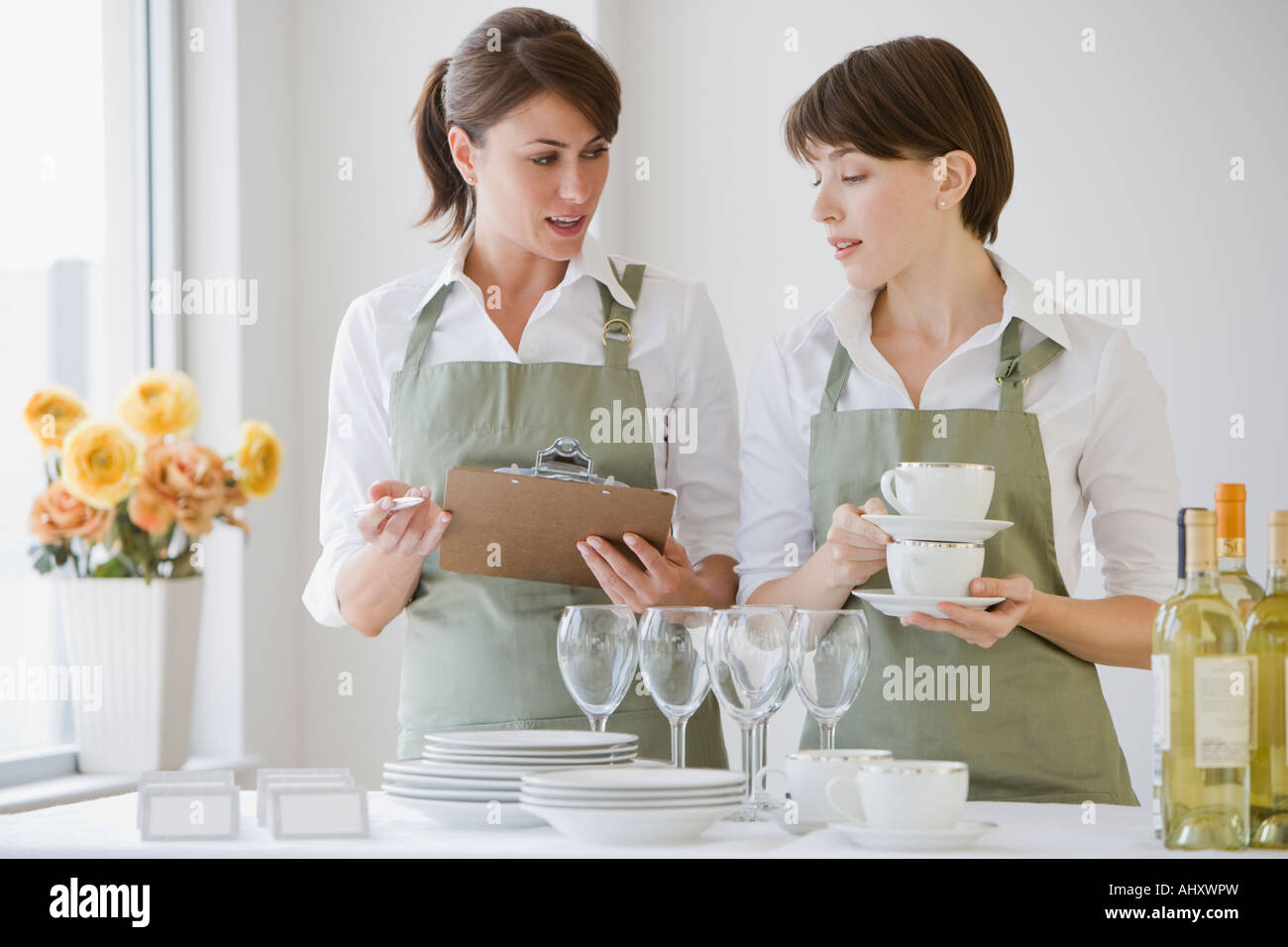Two female caterers with dishware Stock Photo - Alamy