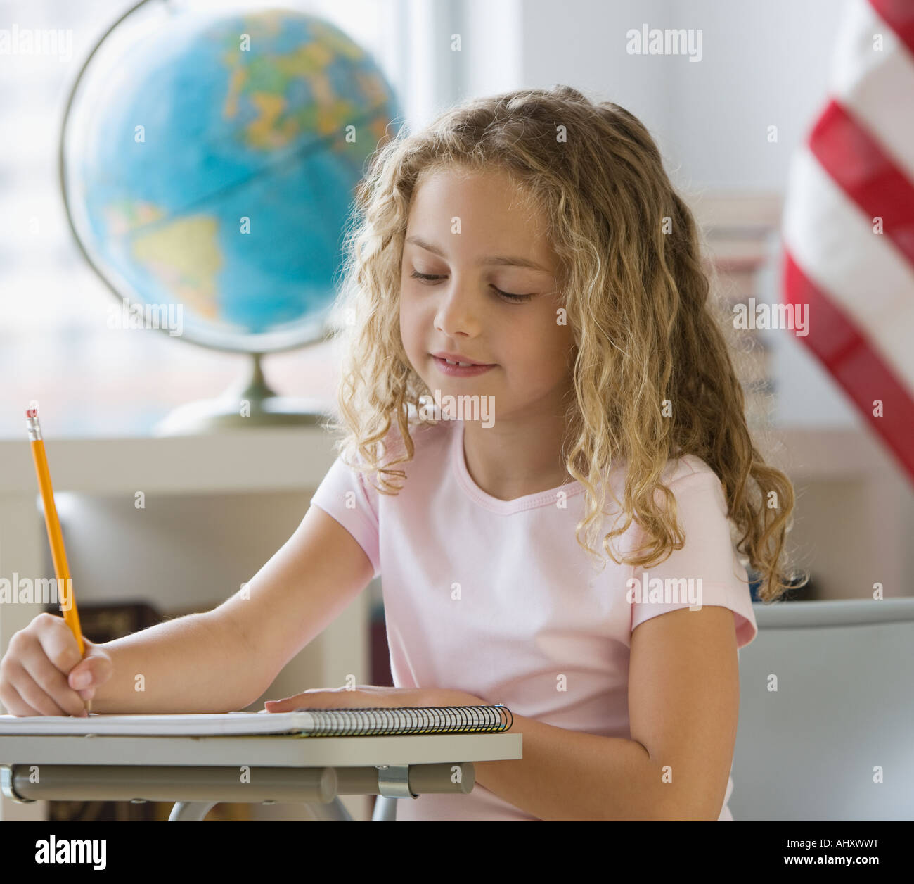 Girl writing at school desk Stock Photo - Alamy
