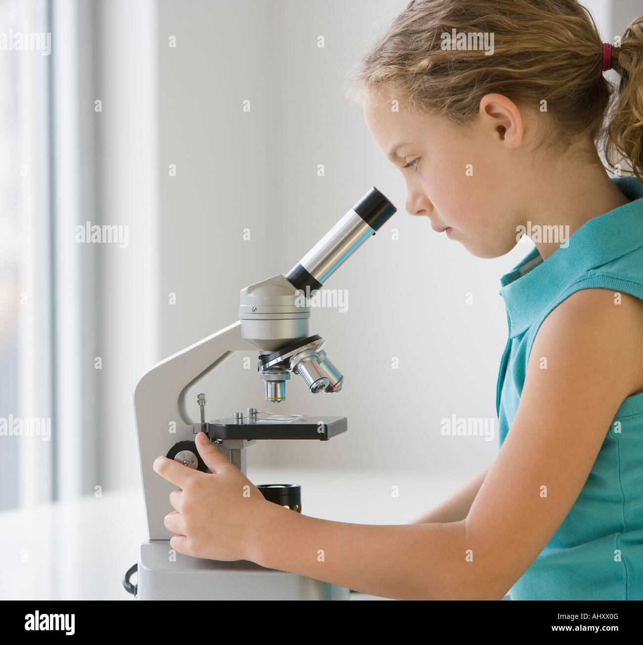Girl looking into microscope Stock Photo - Alamy