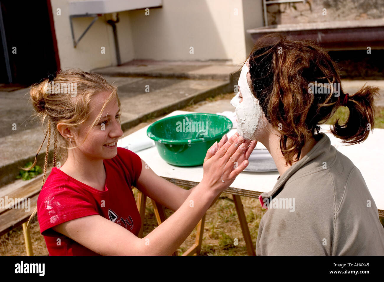 2 girls doing a plaster mask Stock Photo - Alamy