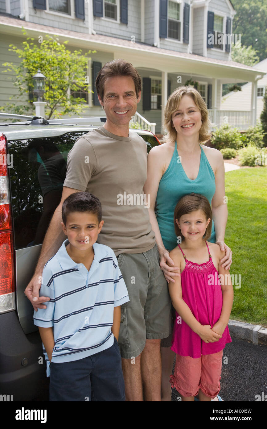 Family standing behind car Stock Photo - Alamy