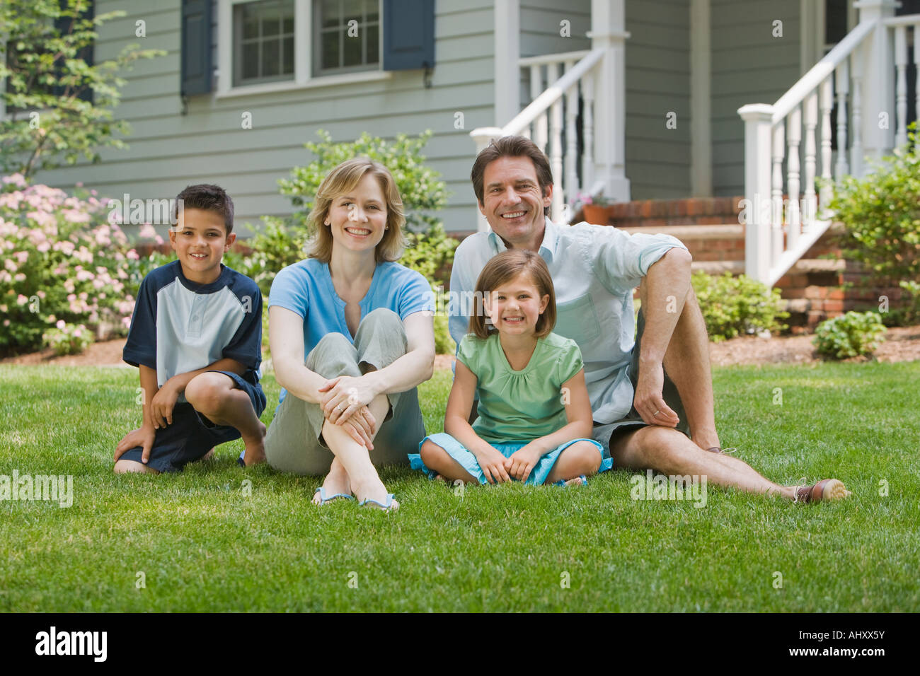 Family sitting on lawn Stock Photo - Alamy