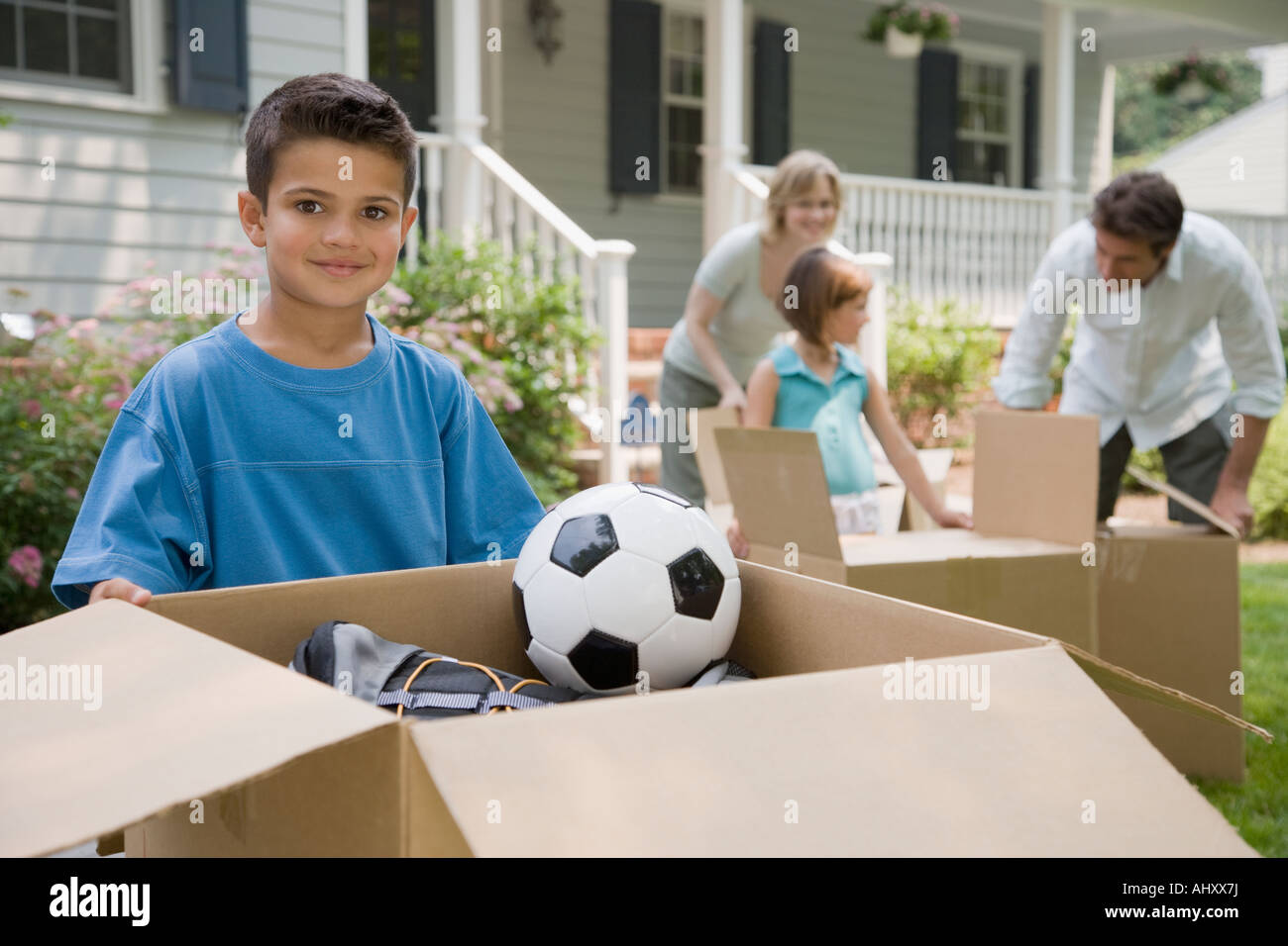 Family unpacking moving boxes Stock Photo - Alamy