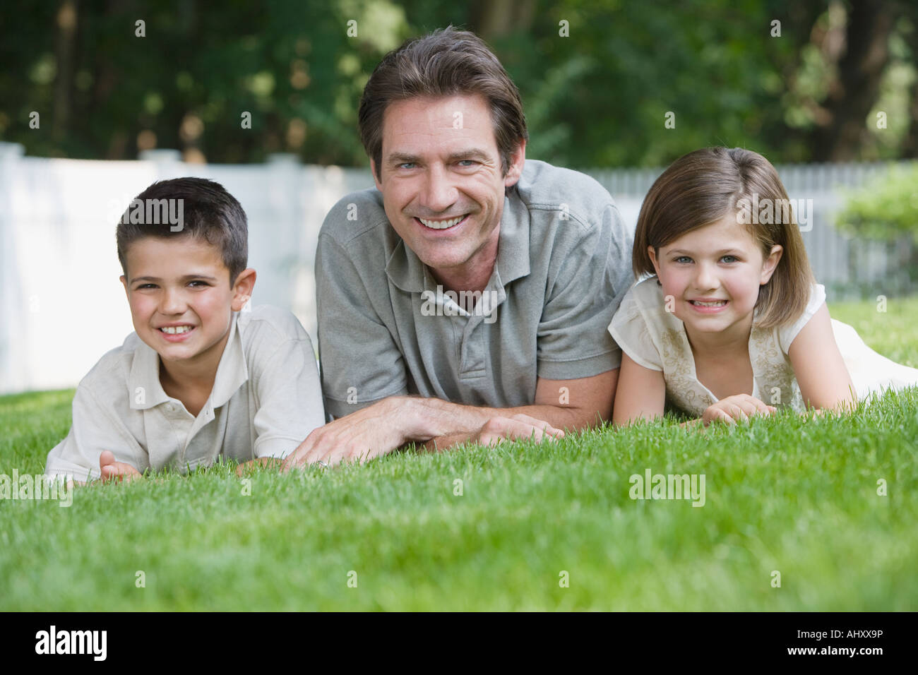 Father and children laying in grass Stock Photo - Alamy
