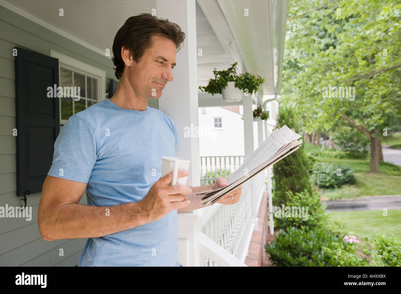 Man reading newspaper on porch Stock Photo - Alamy