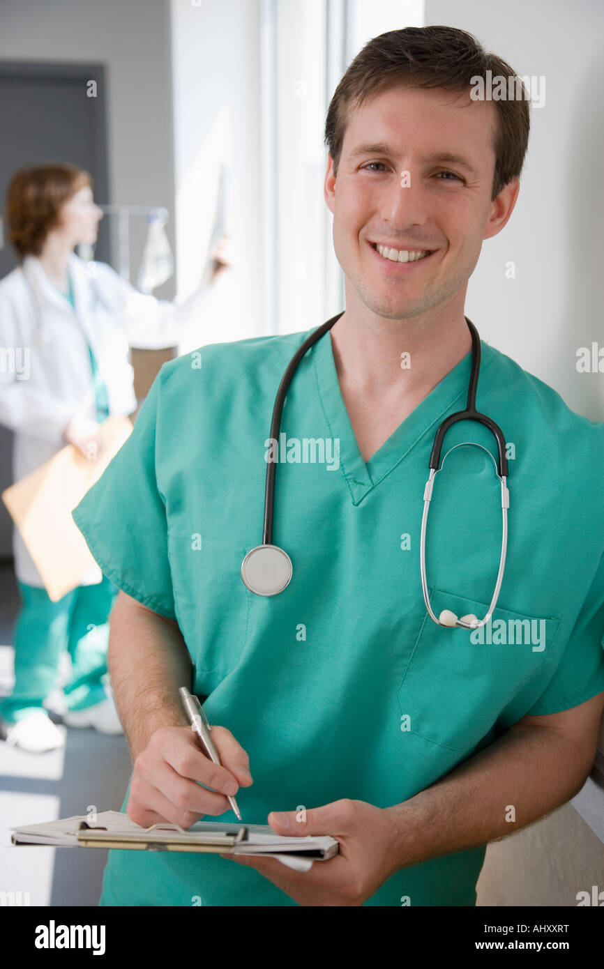 Male doctor writing on chart Stock Photo - Alamy
